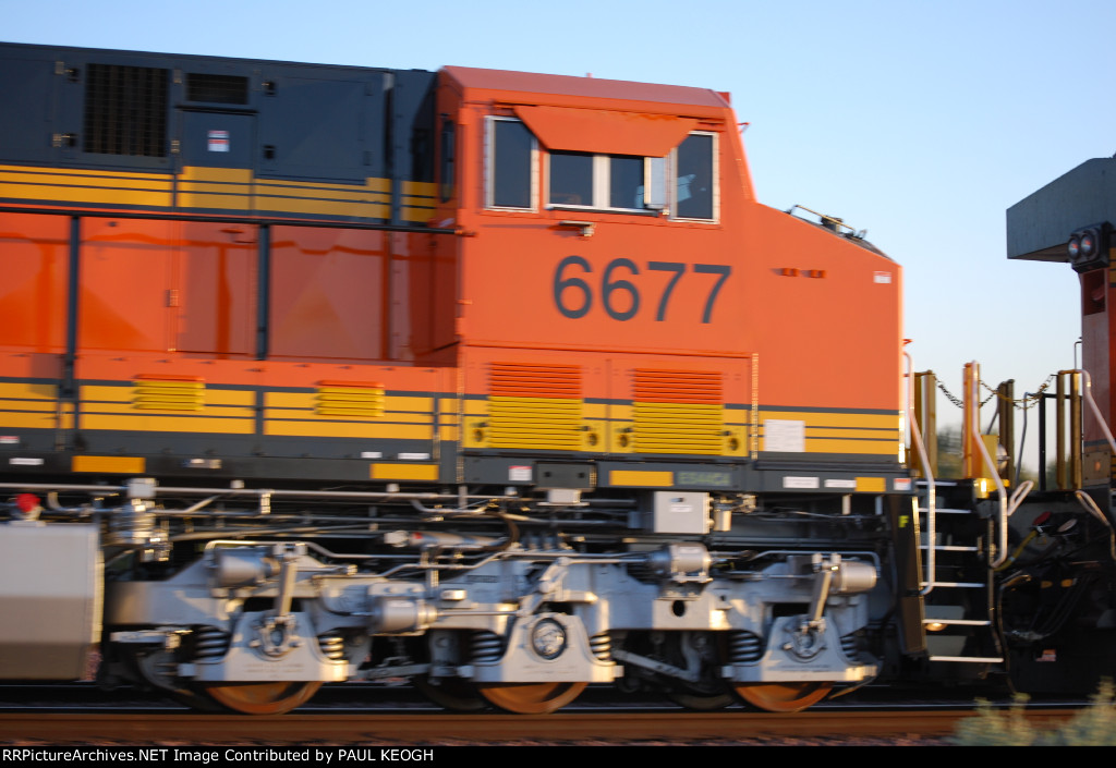 BNSF 6677 side shot as she passes me by doing about 45 MPH as the Rising Sun Reflects off Her ...